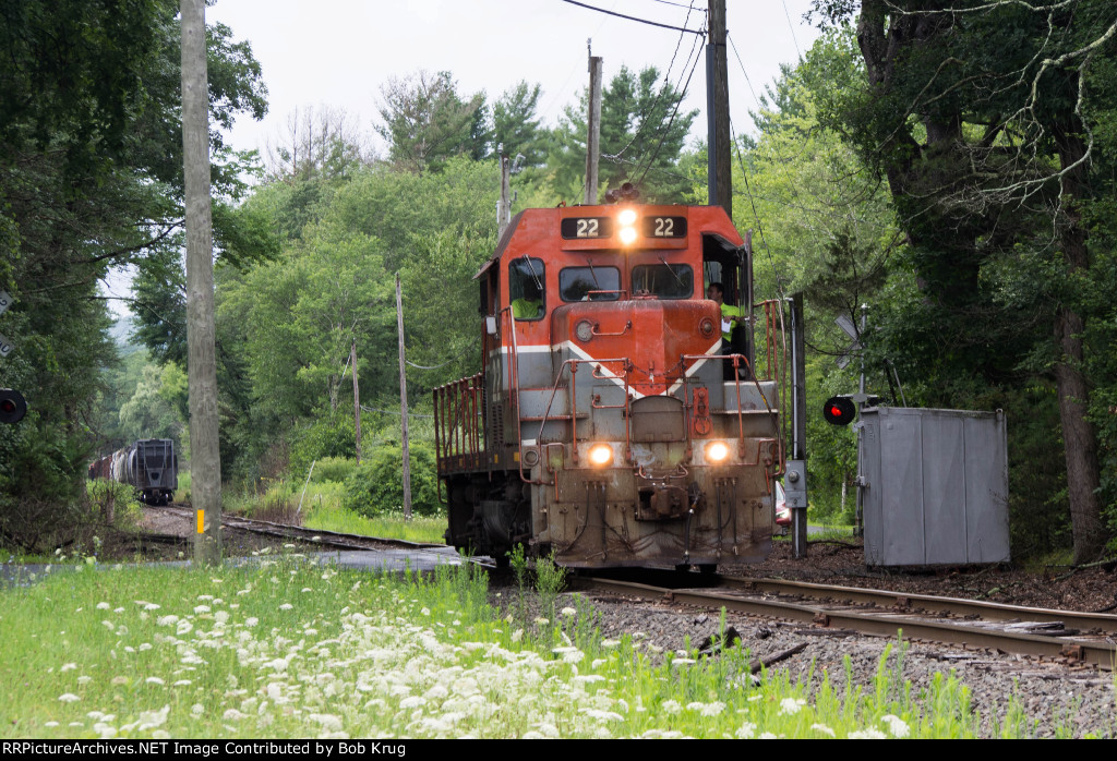 HRRC 22, ex-Bangor & Aroostook crosses Sand Road after coupling a string of covered hoppers to ...